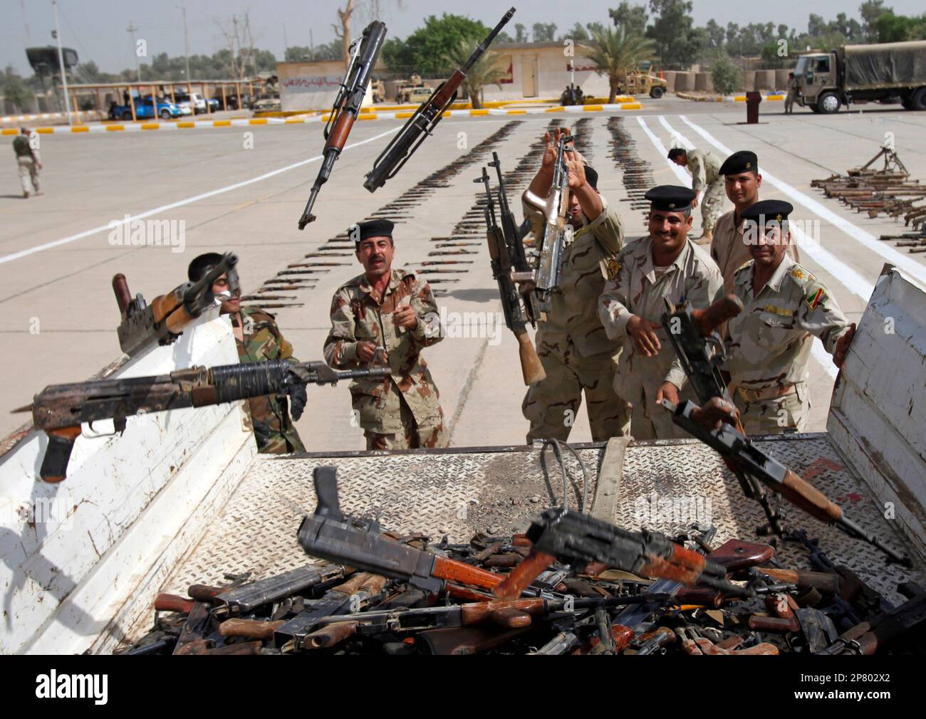 Iraqi Army soldiers load a truck carrying weapons seized by Iraqi ...