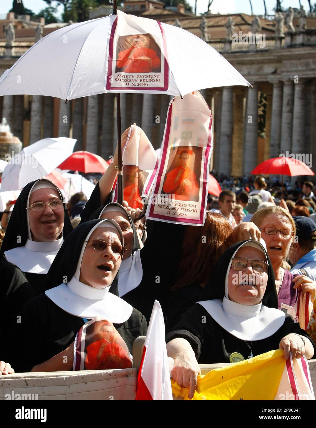 Polish nuns, holding photos and scarves, react during a canonization ...