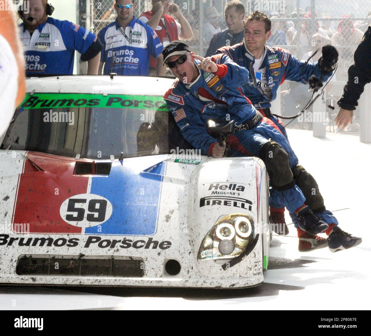 Members of Brumos Racing team celebrate by riding the car driven by ...