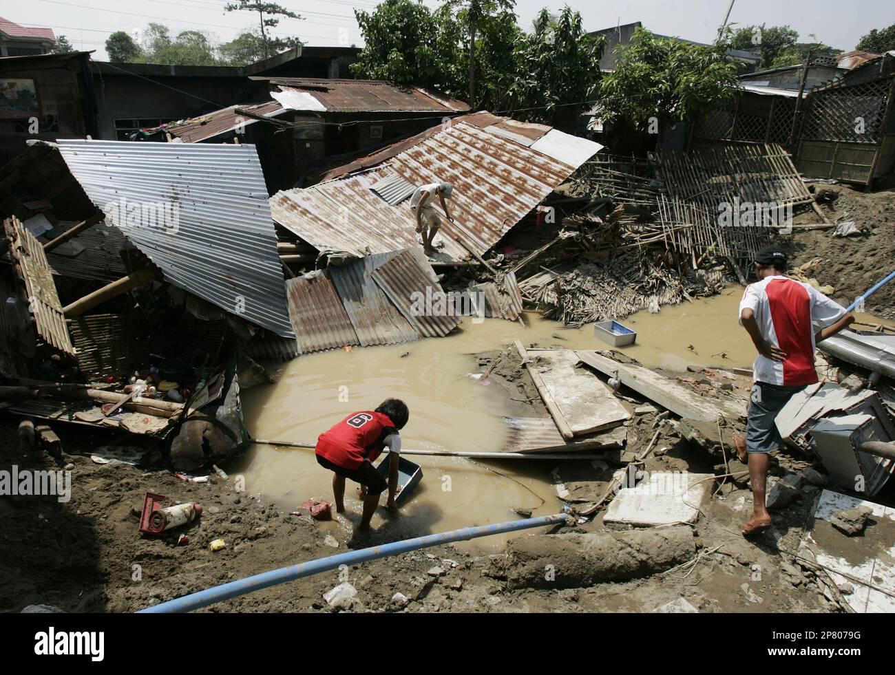 Residents look at their damaged house in Rosales town, Pangasinan ...