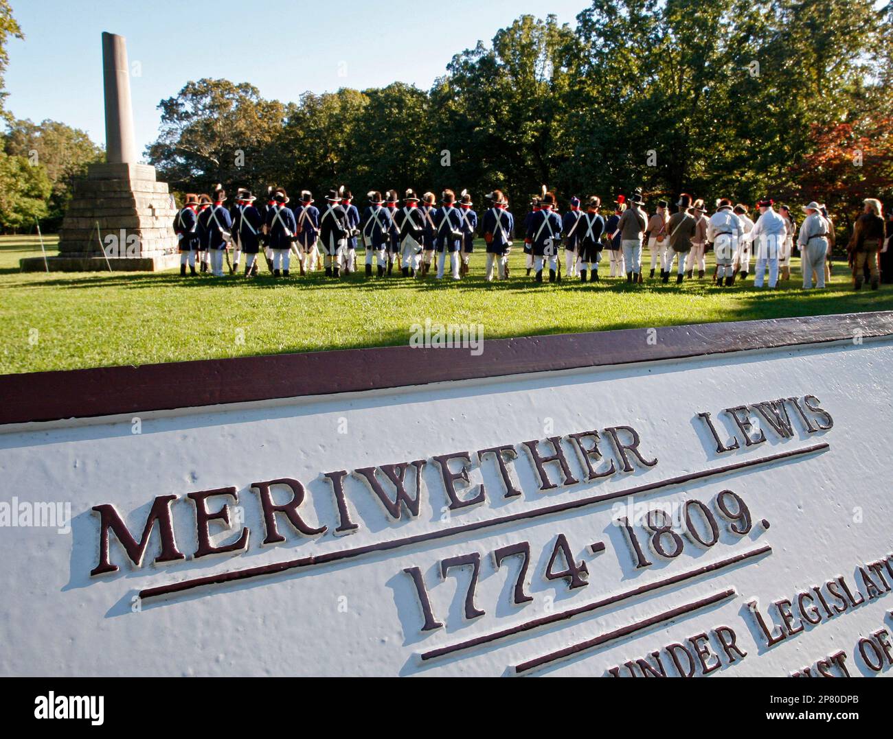 Actors in period battle uniforms stand at the grave of Meriwether Lewis ...