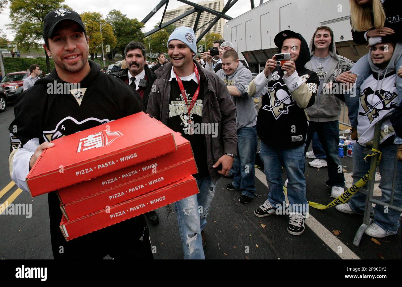Pittsburgh Penguins' Max Talbot, left, hands out pizzas to students ...
