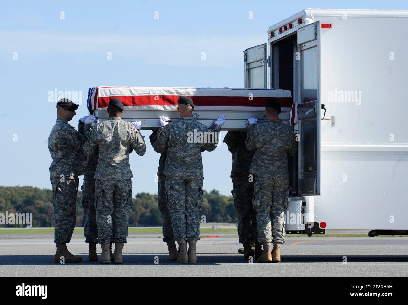 A carry team loads the transfer case containing the remains of Army Spc ...