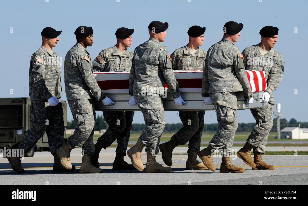 A carry team carries the transfer case containing the remains of Army ...
