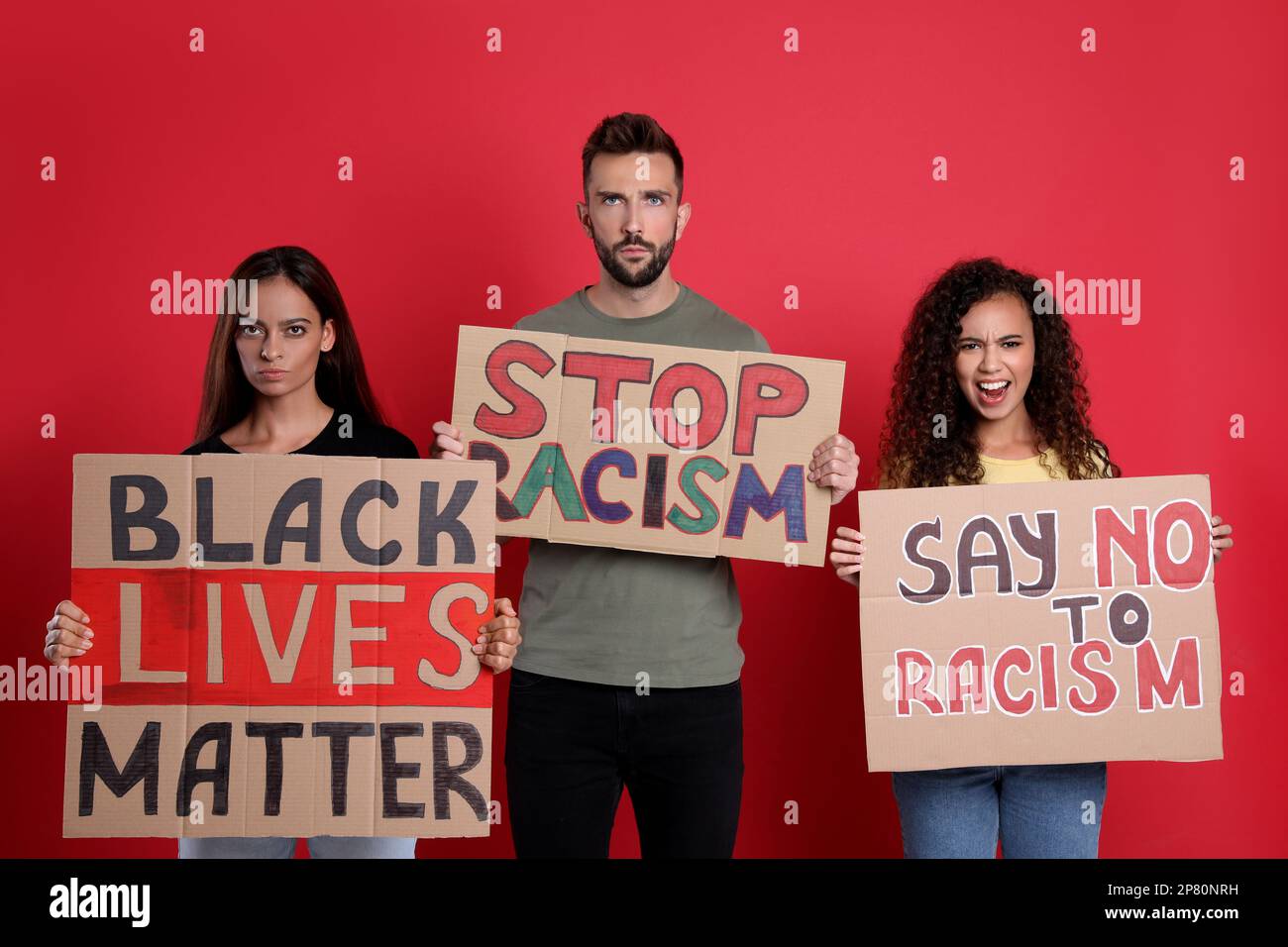 Protesters demonstrating different anti racism slogans on red ...