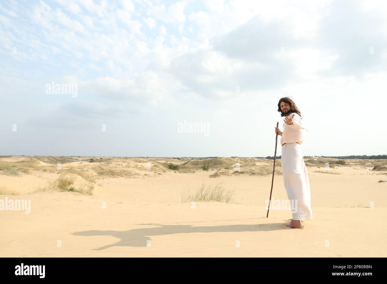 Jesus Christ walking with stick in desert. Space for text Stock Photo ...