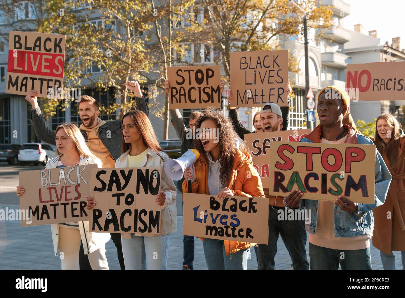 Protesters demonstrating different anti racism slogans outdoors. People ...