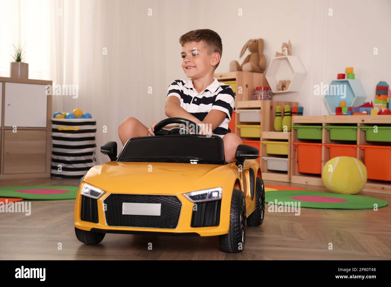 Cute little boy driving big toy car at home Stock Photo - Alamy