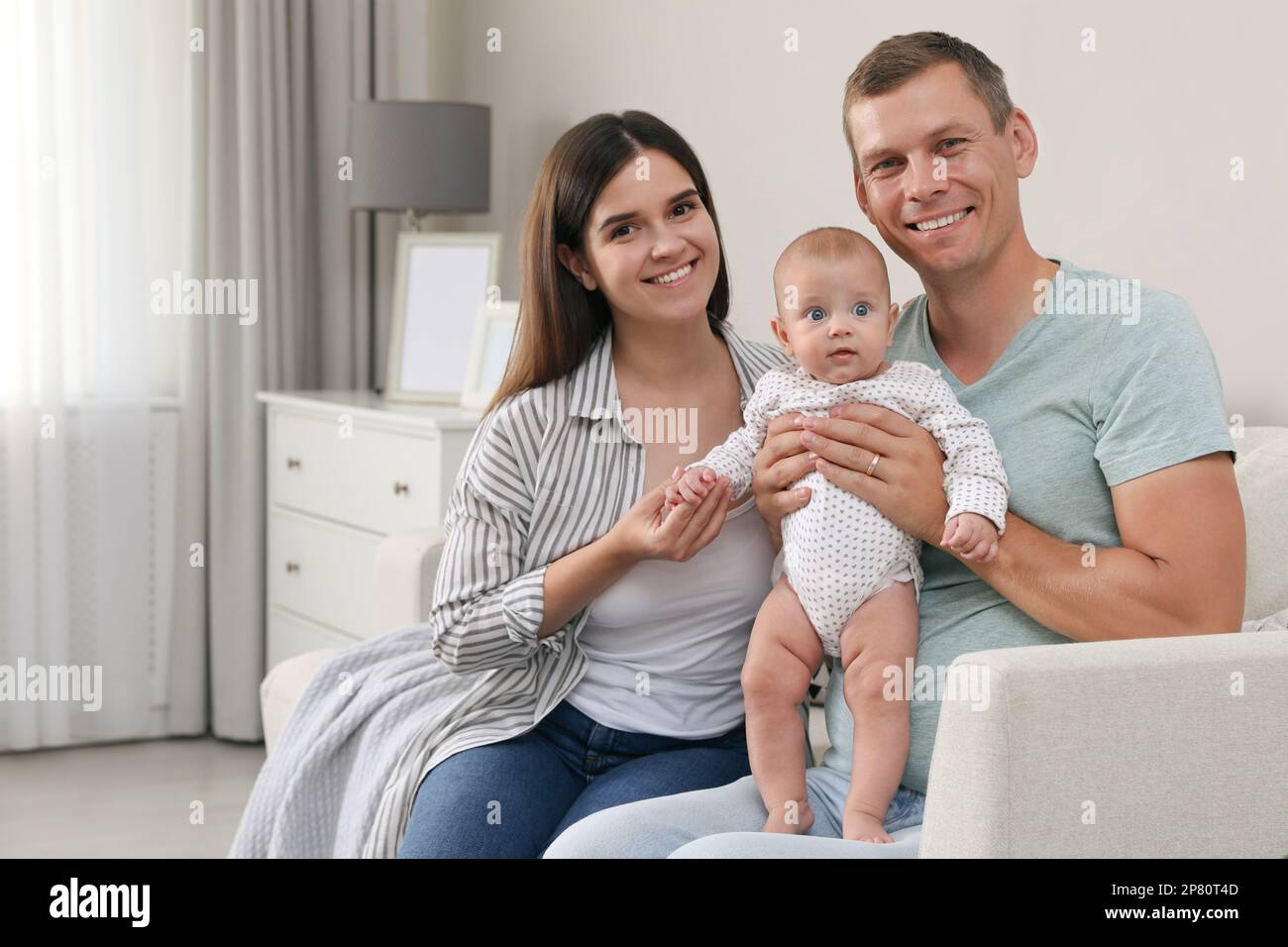 Happy family with their cute baby in living room at home Stock Photo ...