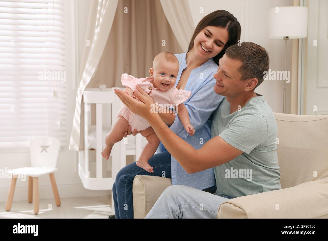 Happy family with their cute baby at home Stock Photo - Alamy