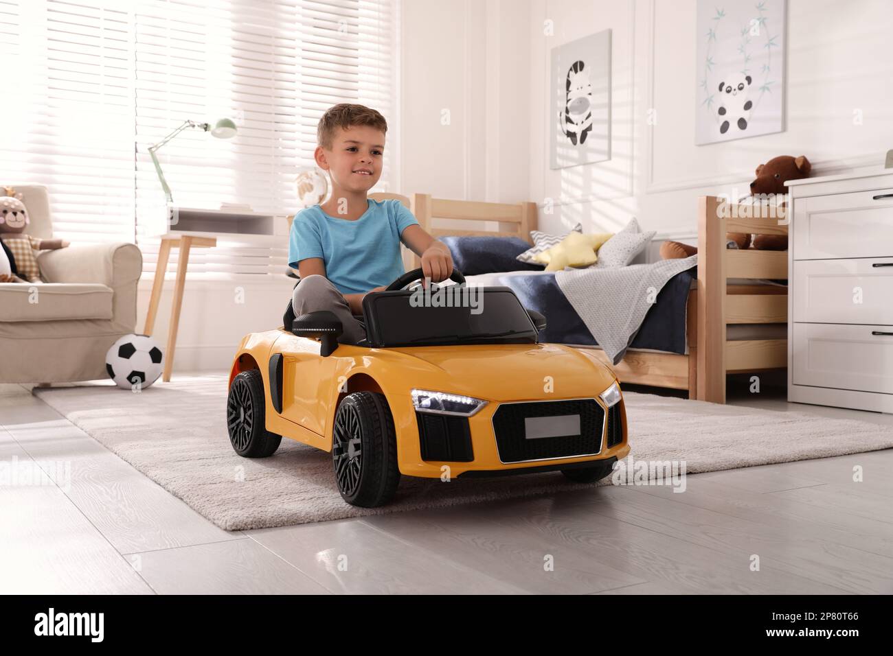 Cute little boy driving big toy car at home Stock Photo - Alamy