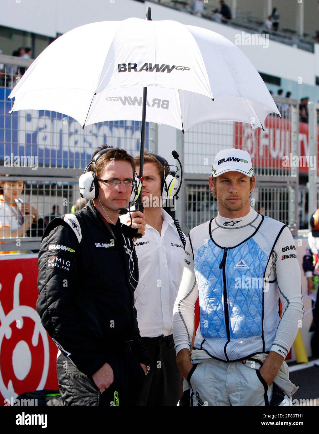Britain's Brawn Formula ONe driver Jenson Button, right, waits on the ...