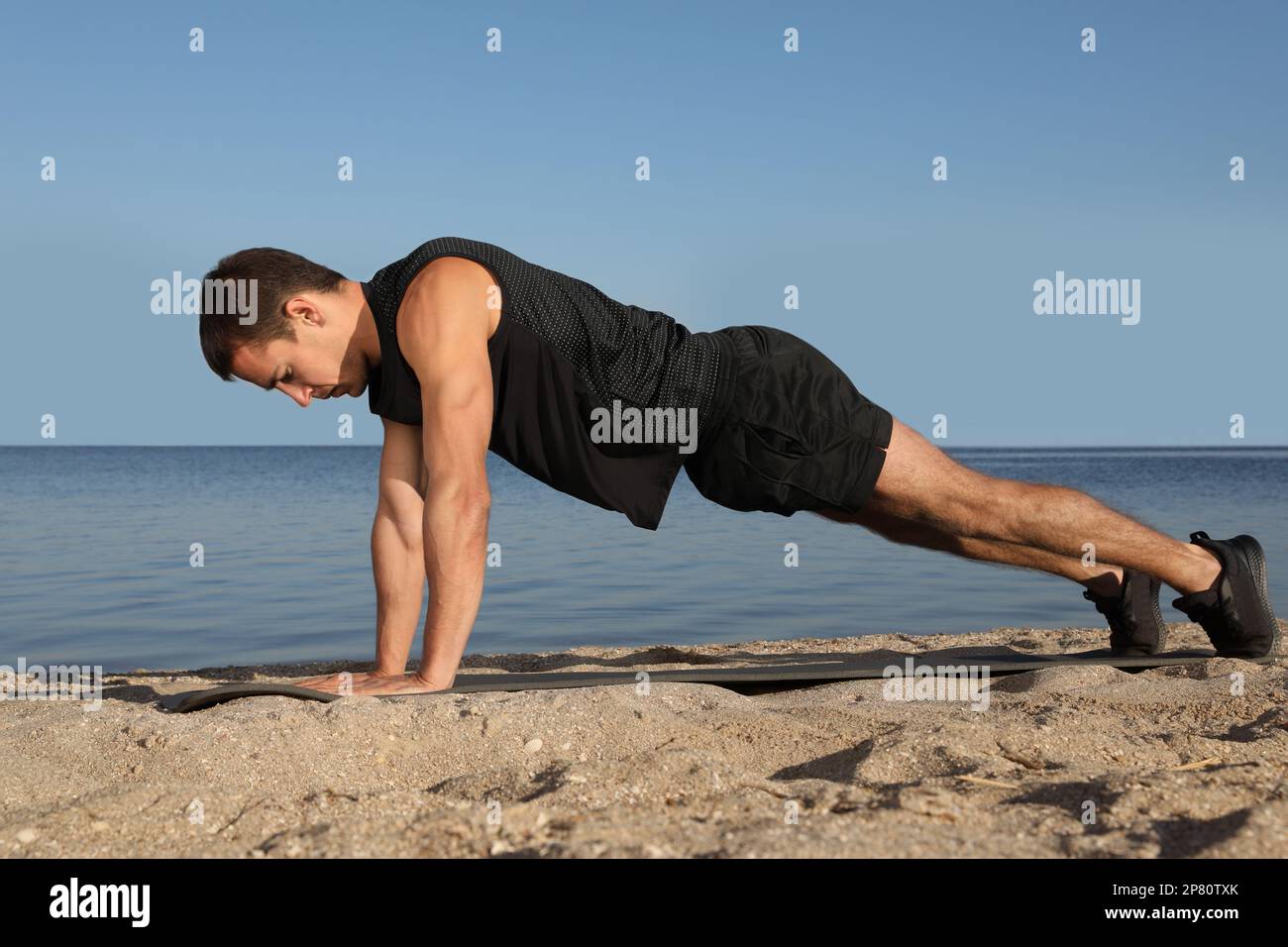 Sporty man doing straight arm plank exercise on beach Stock Photo - Alamy