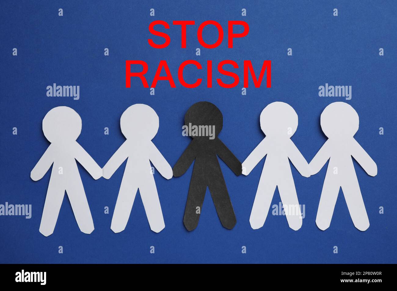 Words Stop Racism made of cubes near white and black paper humans on ...