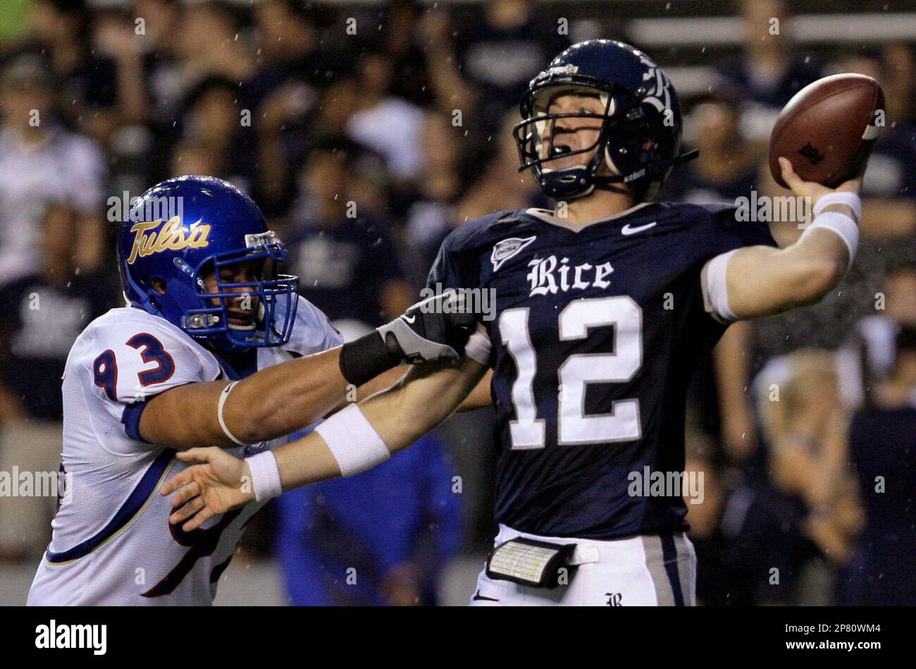 Rice quarterback Ryan Lewis (12) throws a pass as Tulsa defensive end ...
