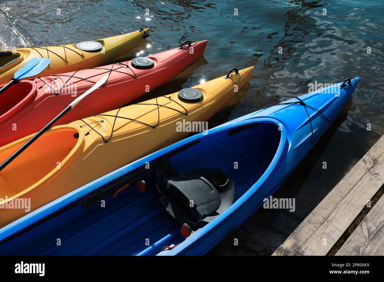 Modern kayaks with paddles on beach near river. Summer camp activity ...