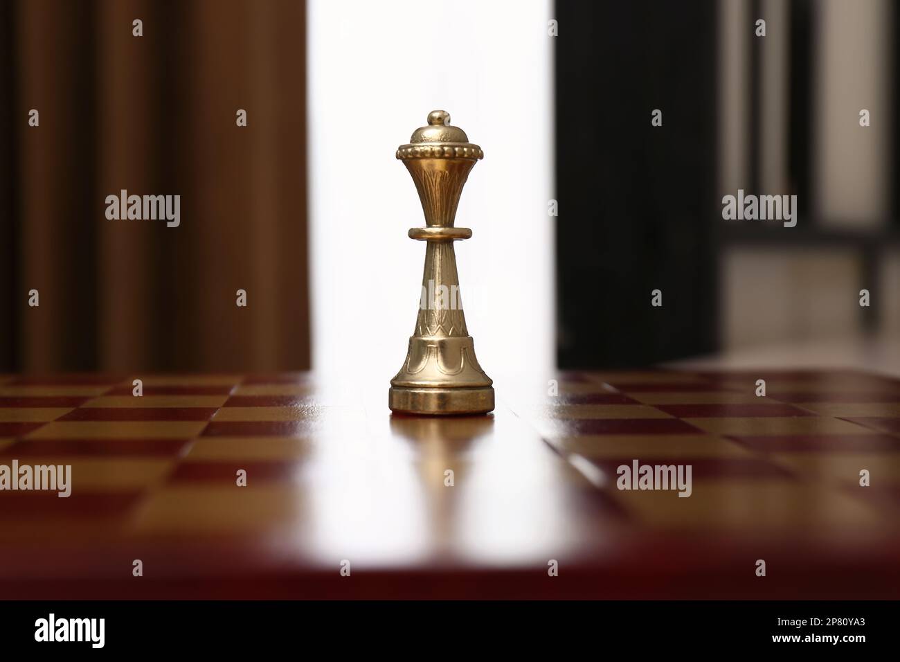 Golden Queen chess piece on board indoors Stock Photo - Alamy