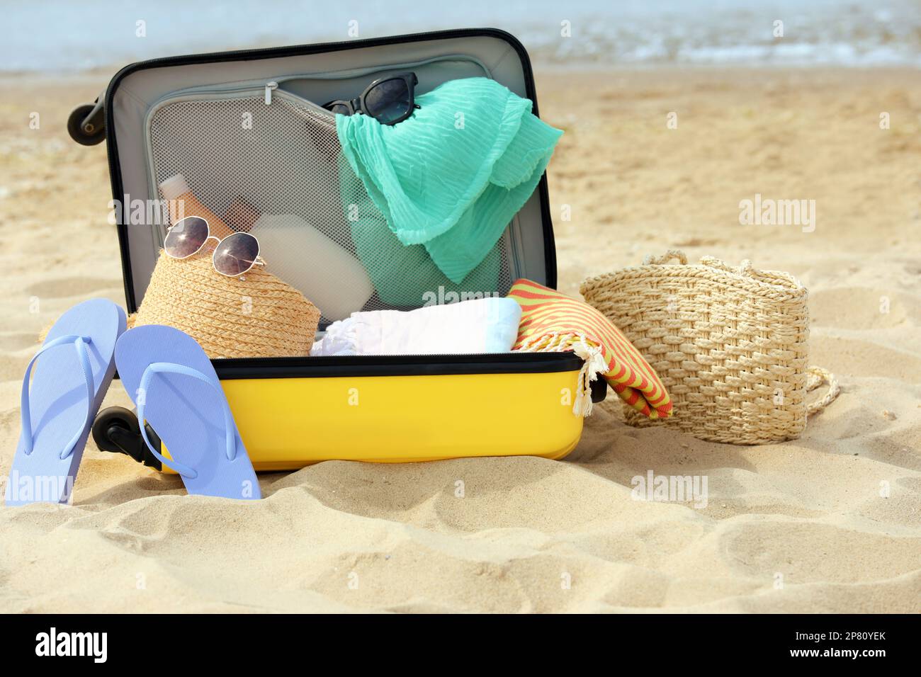 Open suitcase with beach items on sandy seashore Stock Photo - Alamy