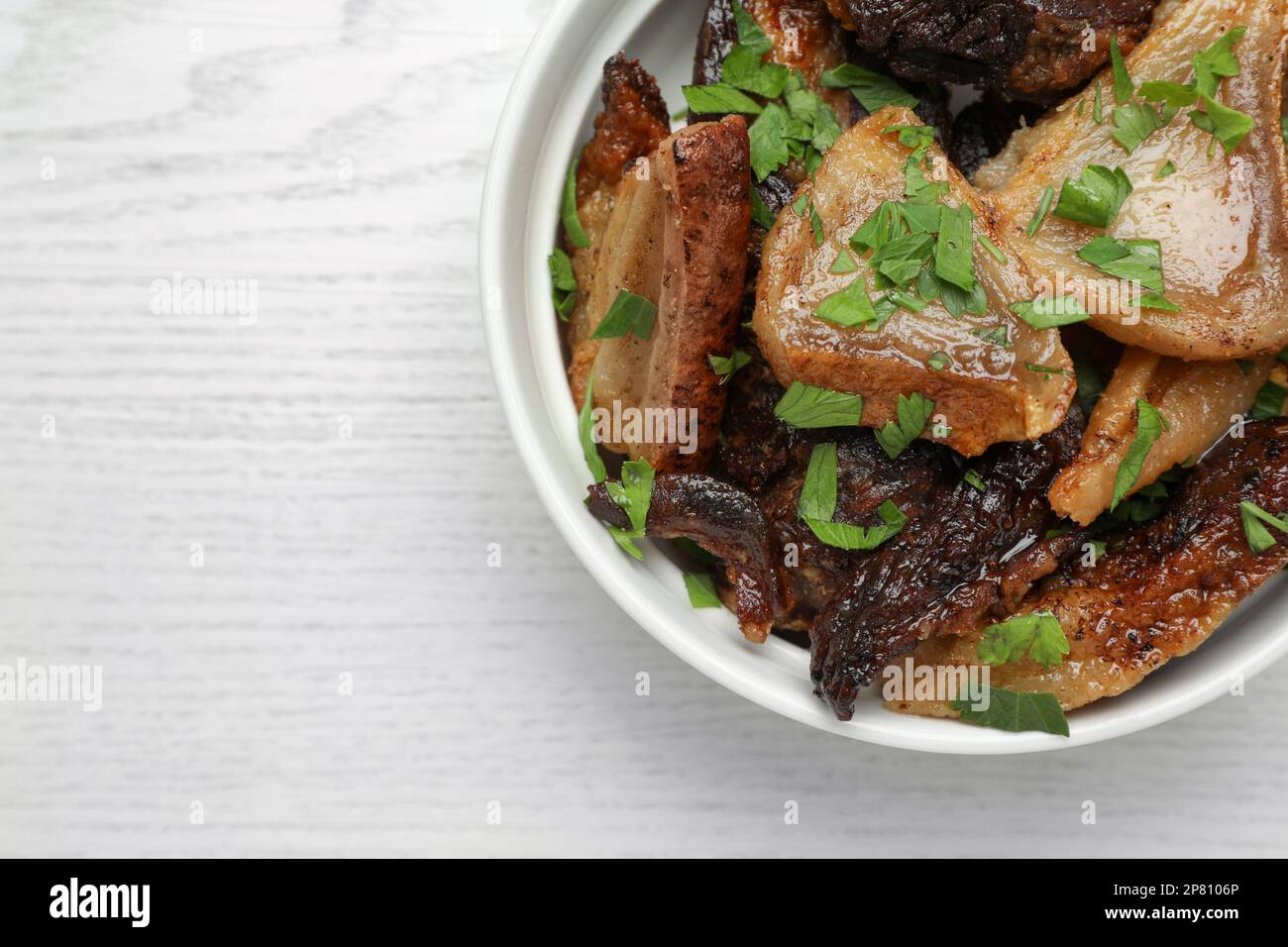 Tasty fried cracklings with parsley on white wooden table, top view and ...