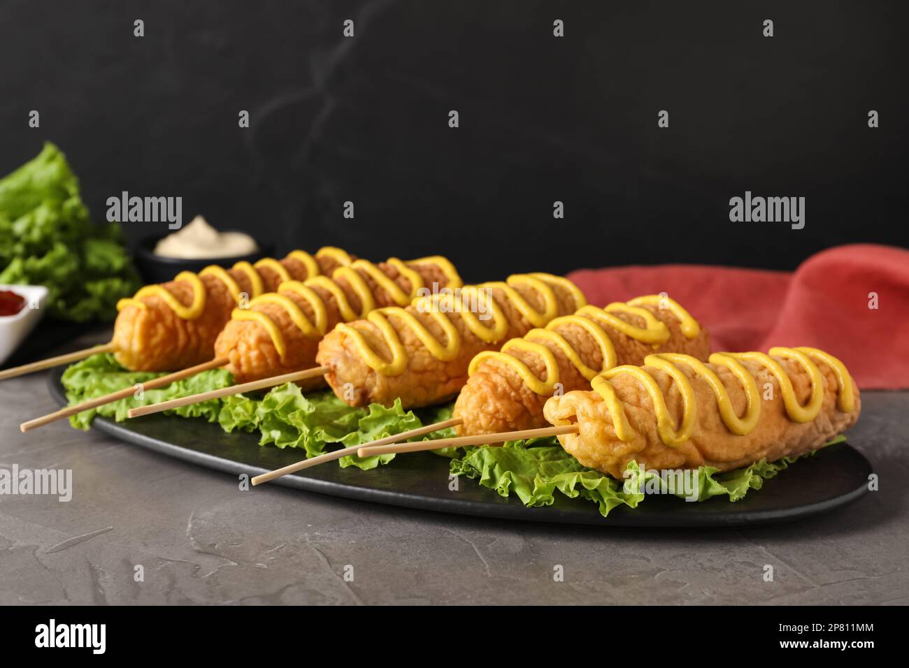 Delicious corn dogs with mustard served on grey table Stock Photo - Alamy