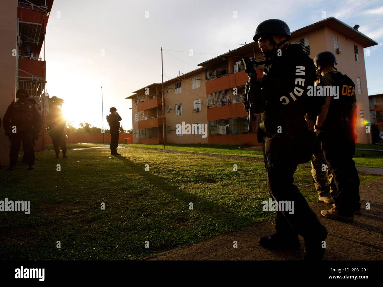 DEA agents provide security outside the buildings of a housing project ...