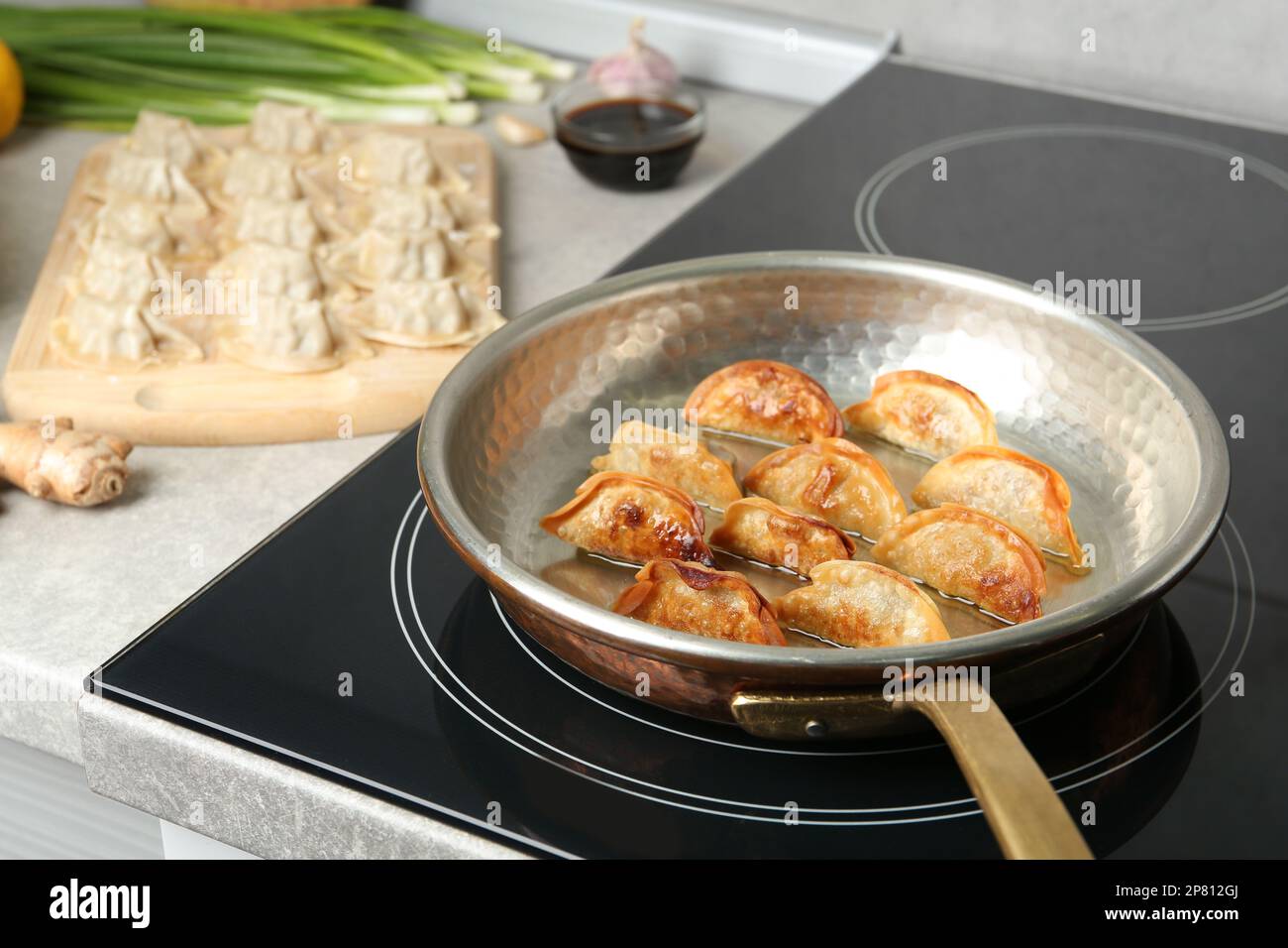 Cooking gyoza on frying pan with hot oil in kitchen Stock Photo - Alamy