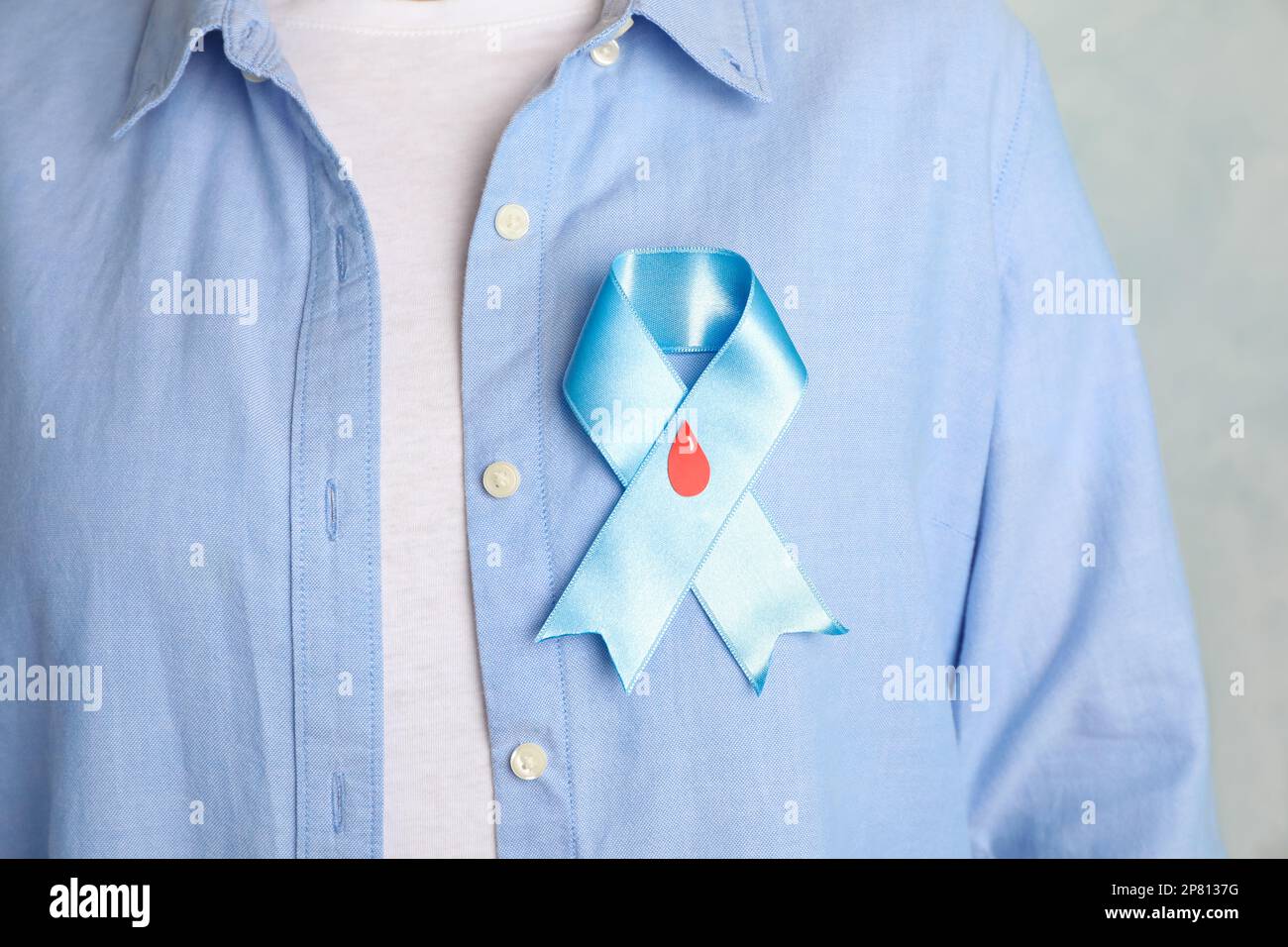 Woman with light blue ribbon and paper blood drop, closeup. World ...