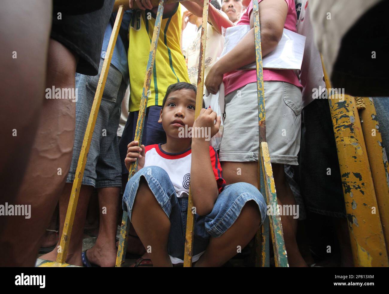 Evacuees queue up for relief supplies at an evacuation center at Cainta ...