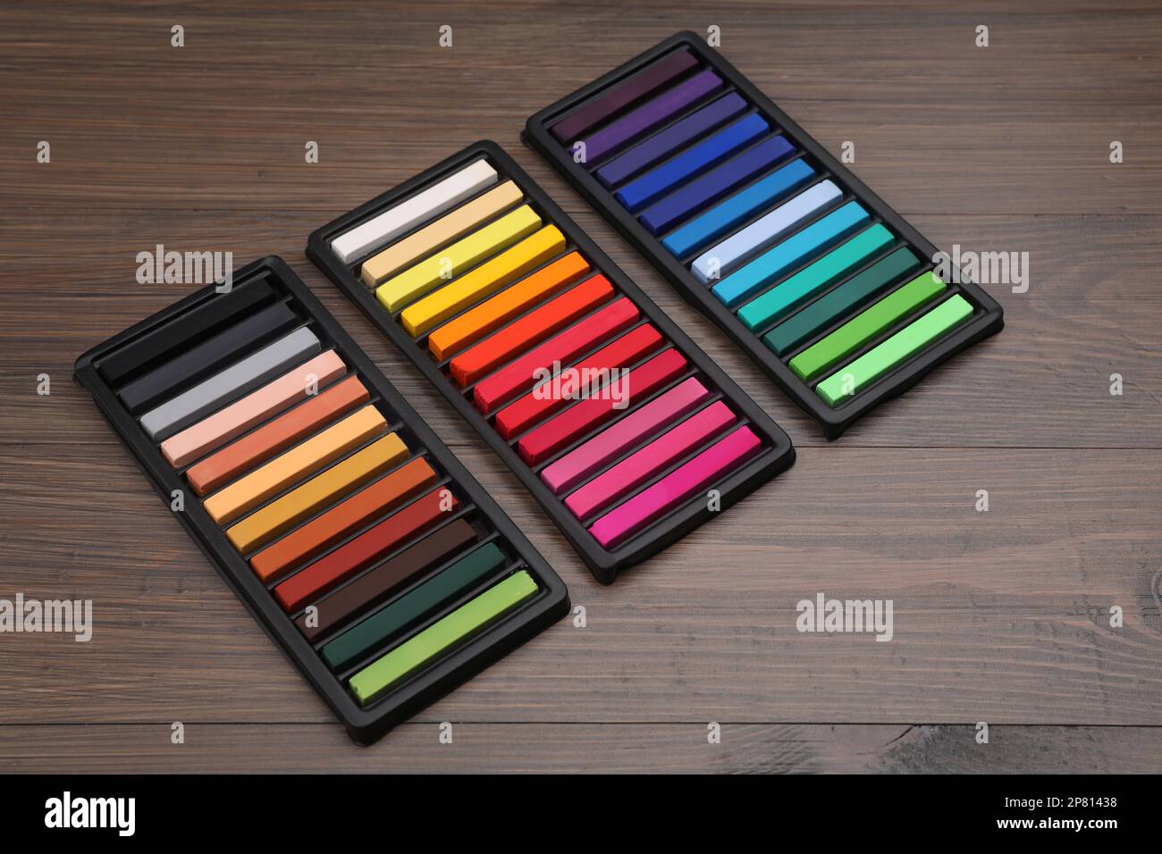 Colorful pastels in trays on wooden table. Drawing materials Stock ...