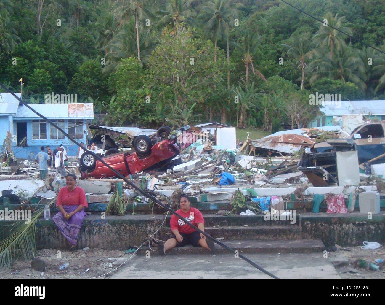 Residents examine the debris of a home on the west side of Tutuila, the ...