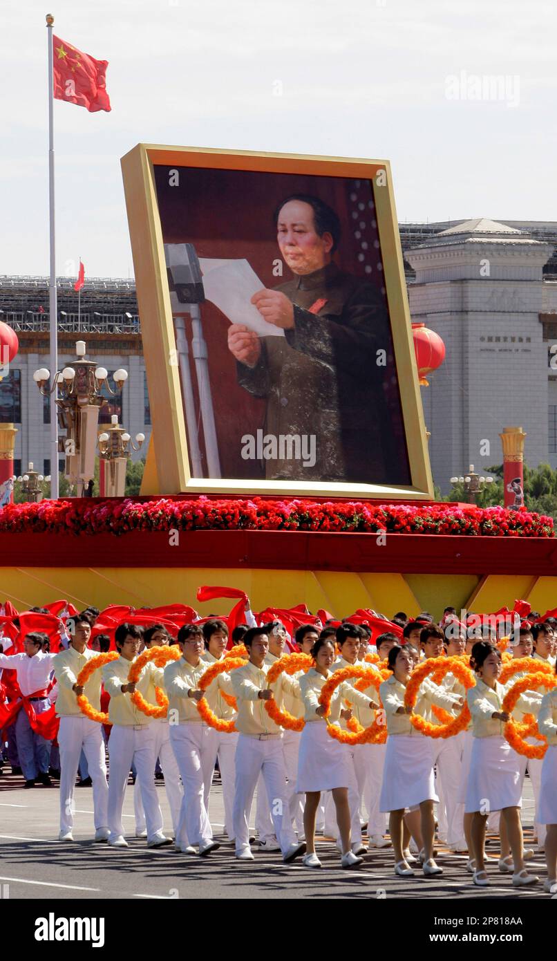 Participants hold a portrait of China's late Chairman Mao Zedong during ...