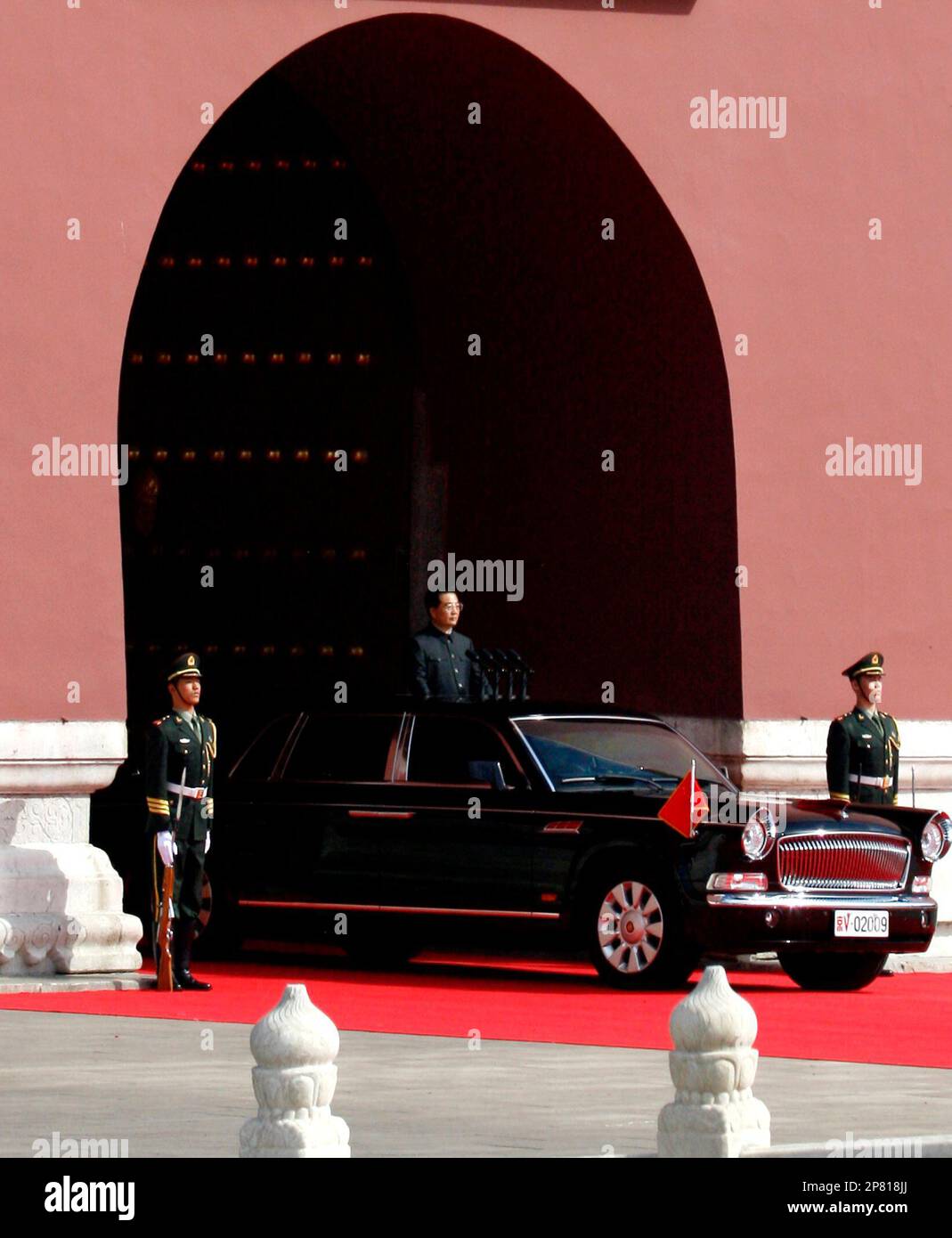 China's President Hu Jintao stands in a limousine to inspect the ...