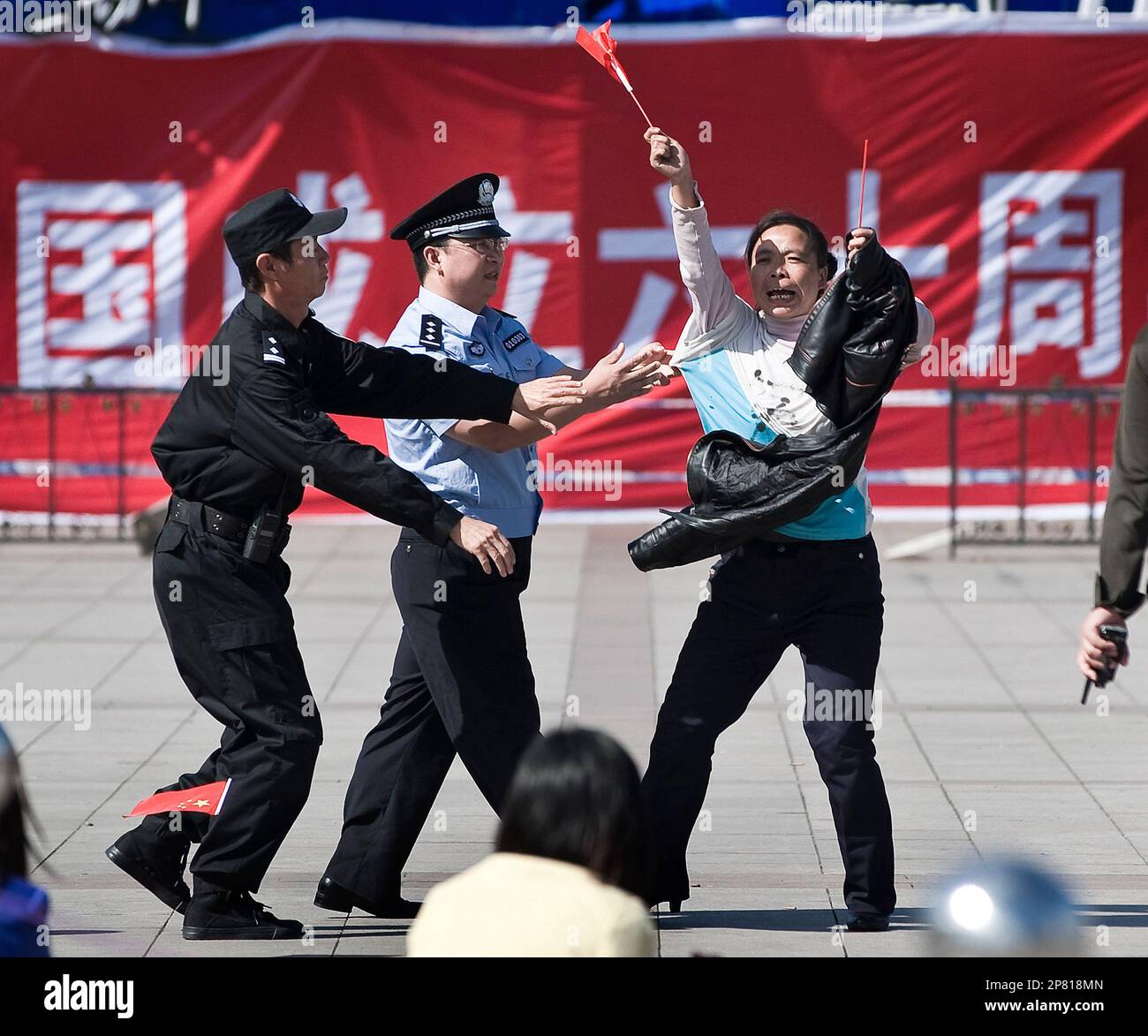 Chinese police officers try to stop a woman chanting a slogan "long ...