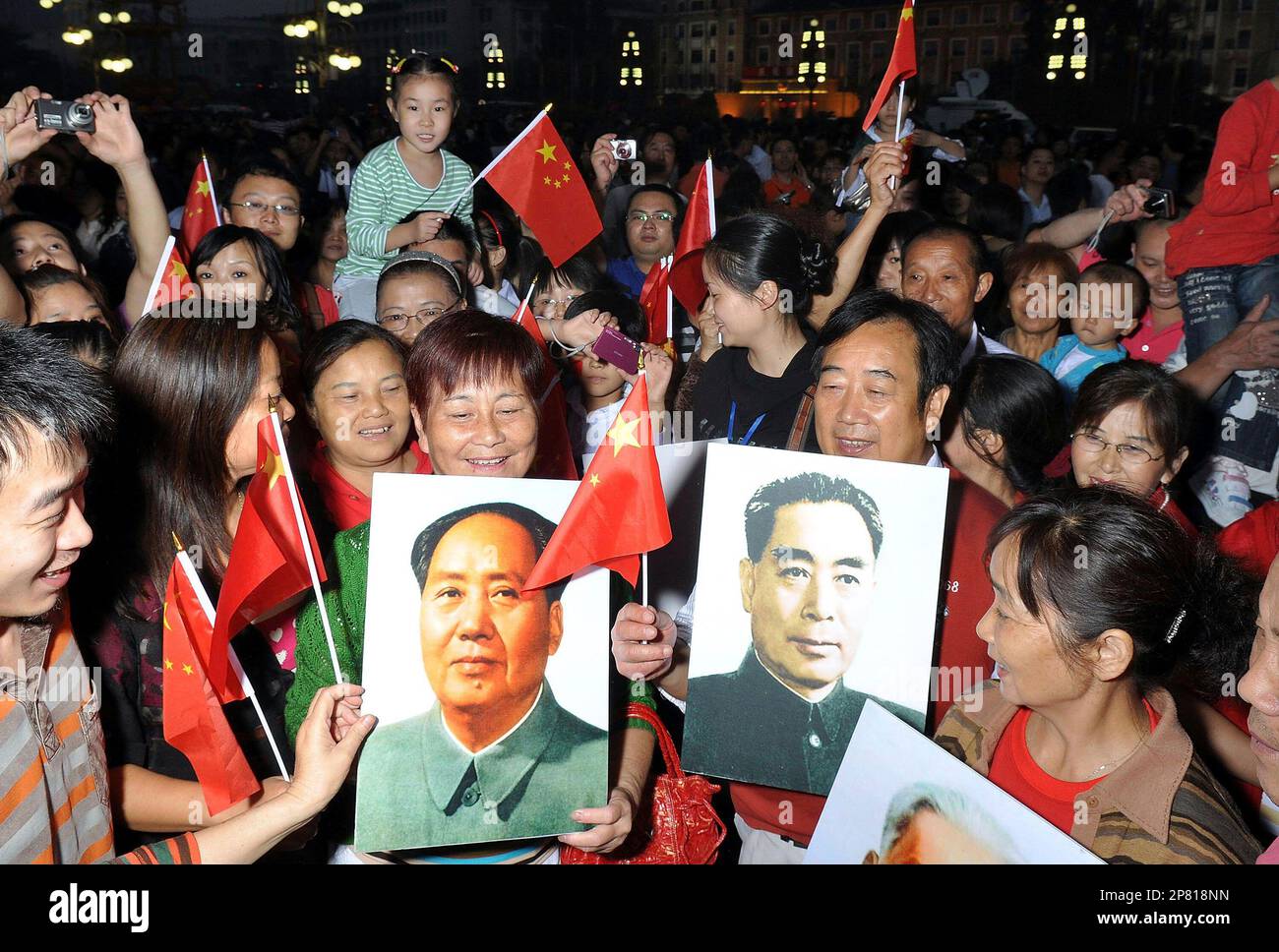 Local residents hold photos of late Chinese leader Mao Zedong, left ...