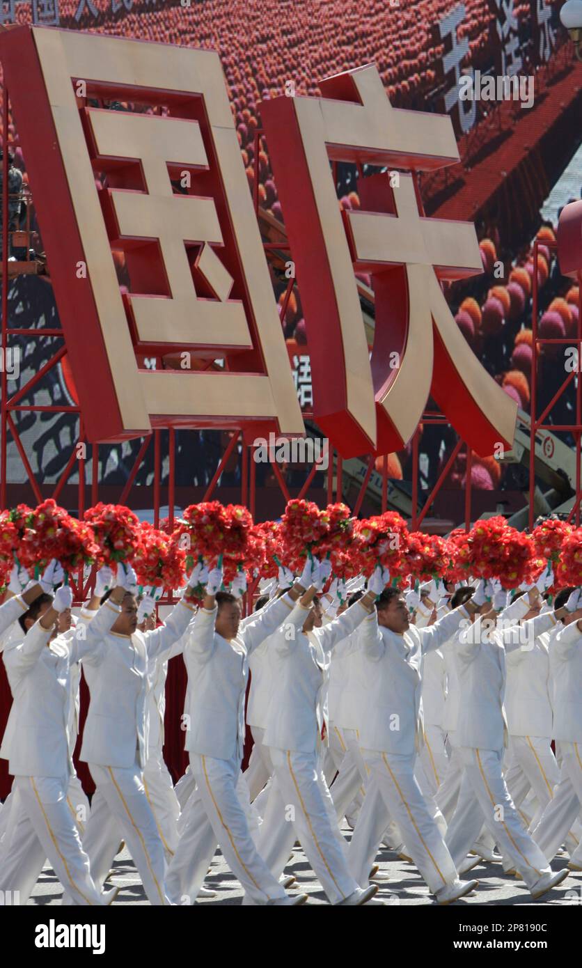 People march with a decoration of Chinese characters reading "National ...