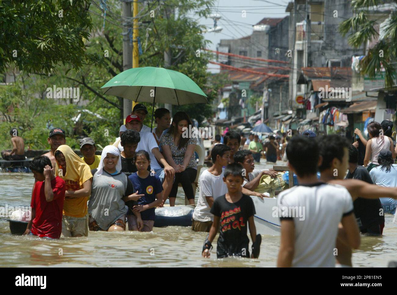 Filipinos negotiate a flooded community in suburban Pasig, east of ...
