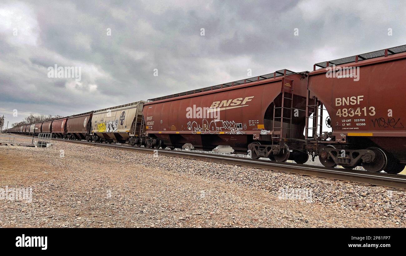 EMPORIA, KANSAS - MARCH 8, 2023 A BNSF freight train hauling grain hopper cars used to transport ...