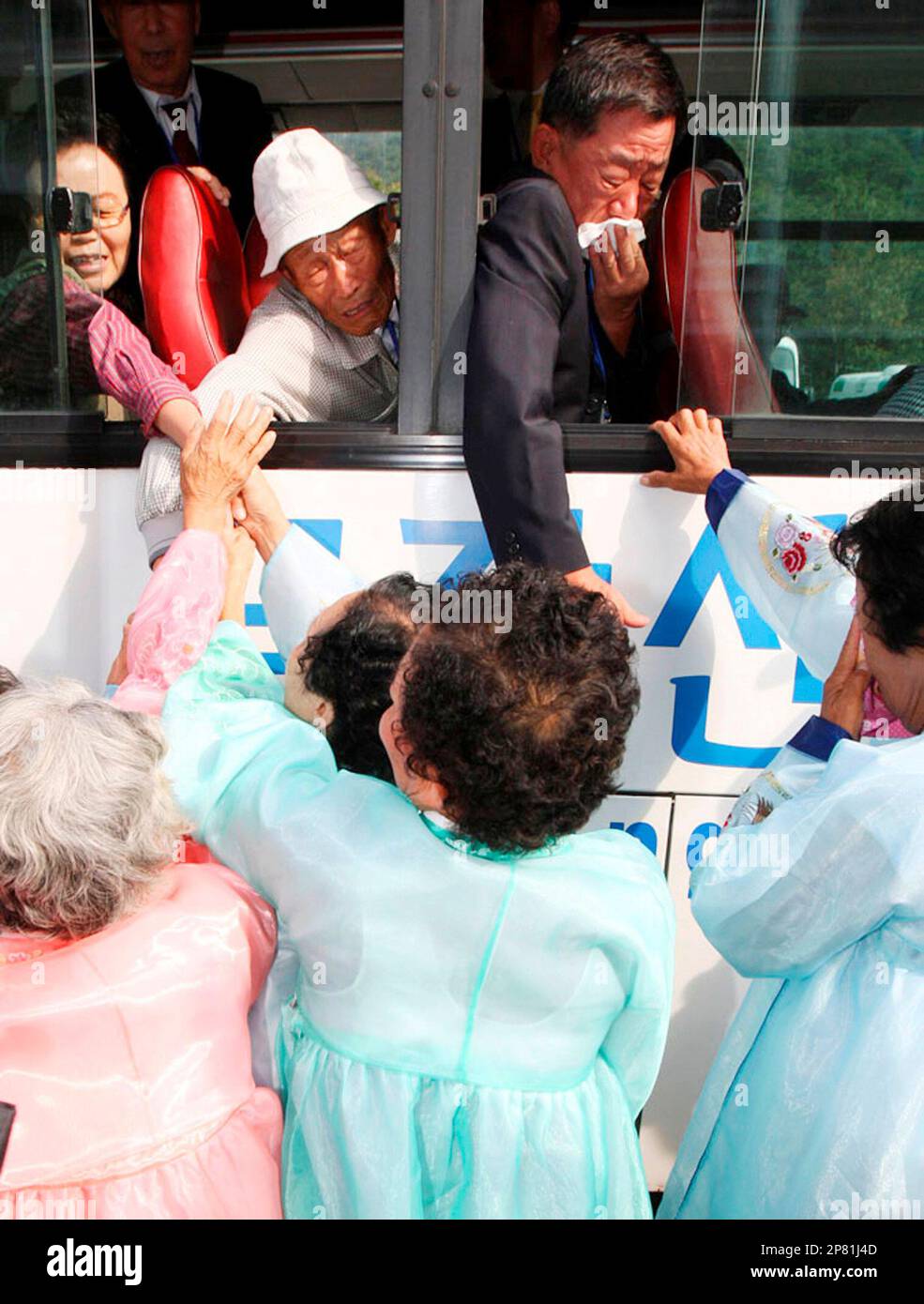 South Korean visitors in a bus cry as they hold the hands of their ...