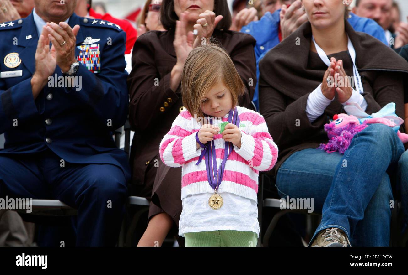 Sophia Duffman, 2, center, wears her Gold Medal of Remembrance, as she ...
