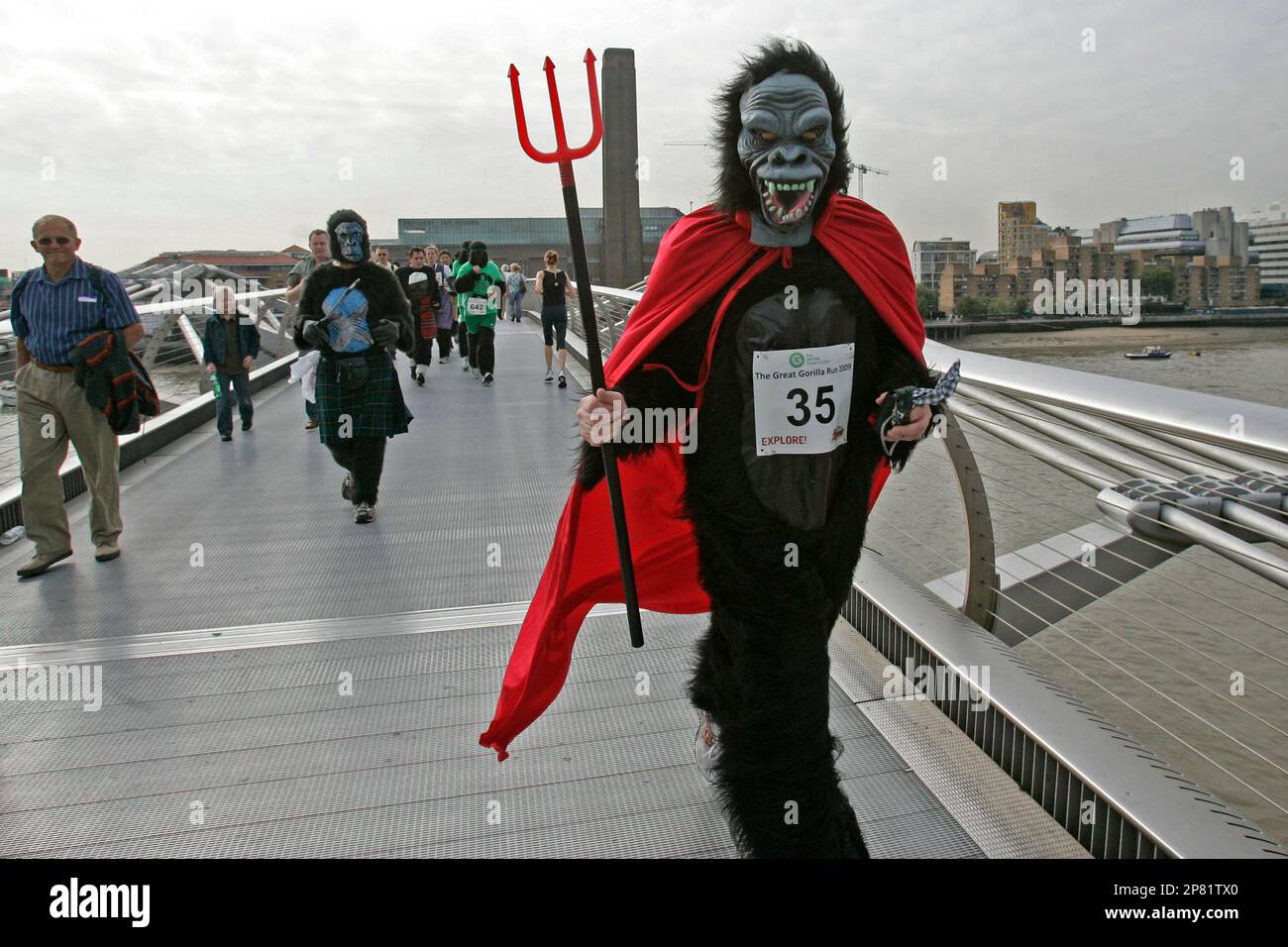 Runners dressed in gorilla costumes run across the Millennium Bridge ...
