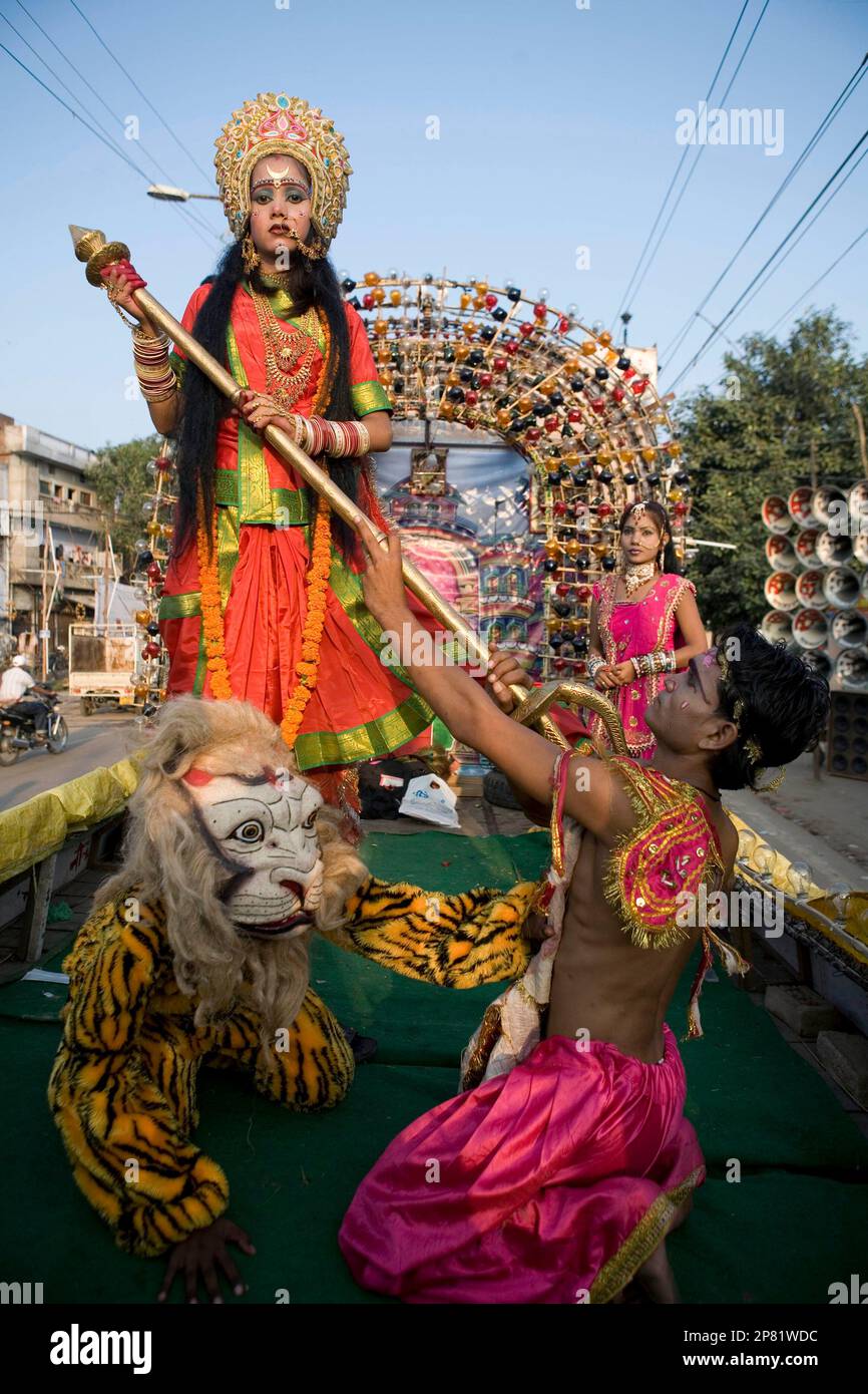 Indian artists dressed as Hindu goddess of valor Durga, left, and demon ...