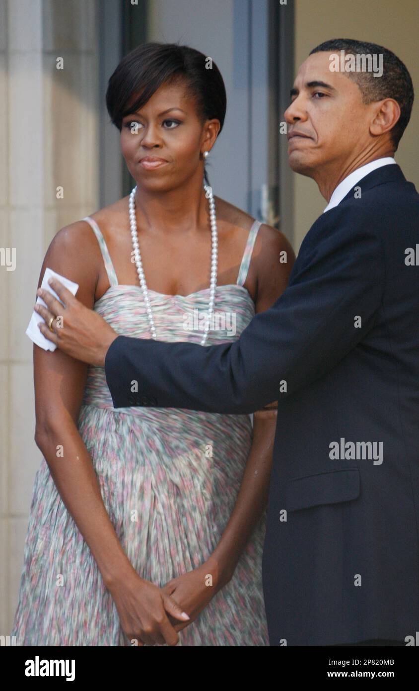 President Barack Obama wipes off drops of rain from first lady Michelle ...