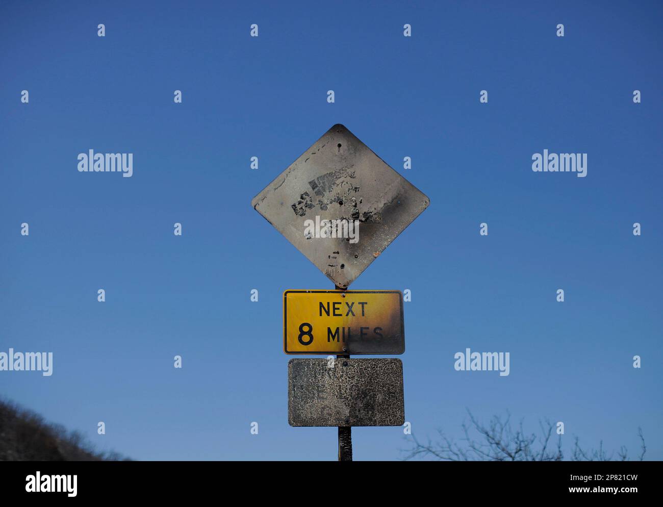 A burned sign stands on the Angeles Crest Highway in the Angeles ...