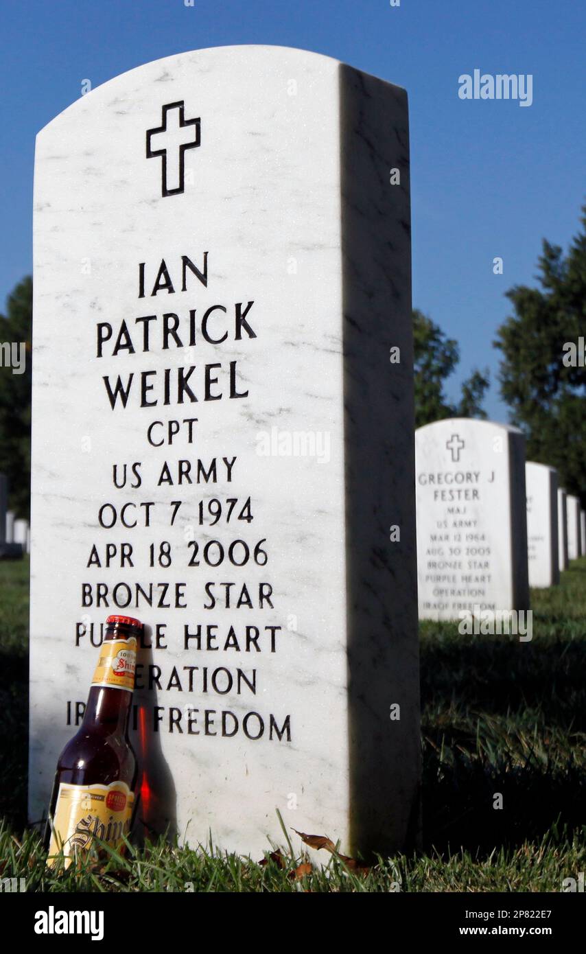 A bottle of beer rests on the grave stone marker for Army Capt. Ian ...