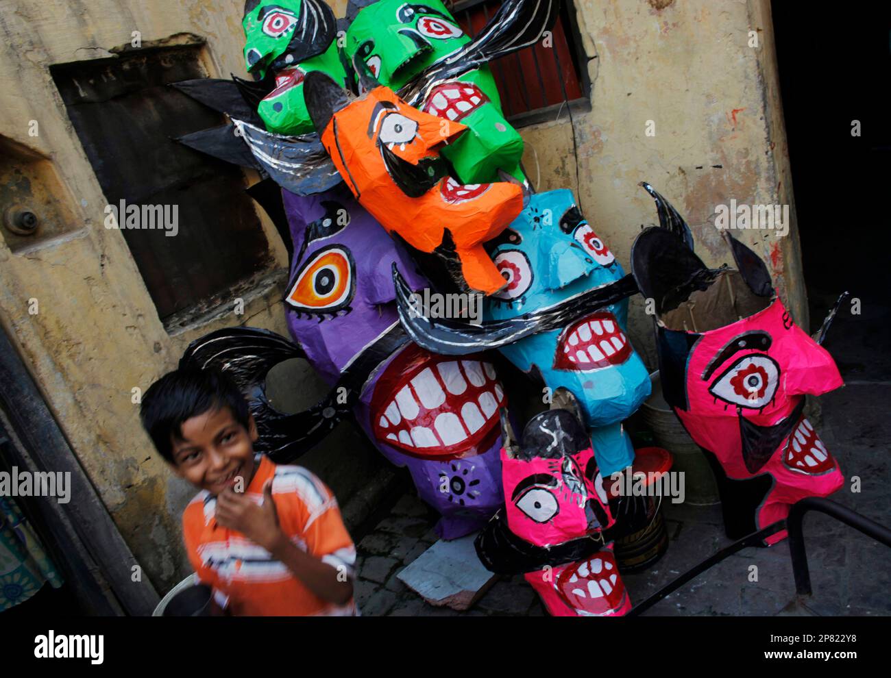 A boy walks past effigies of the ten-headed demon God Ravan, prepared ...