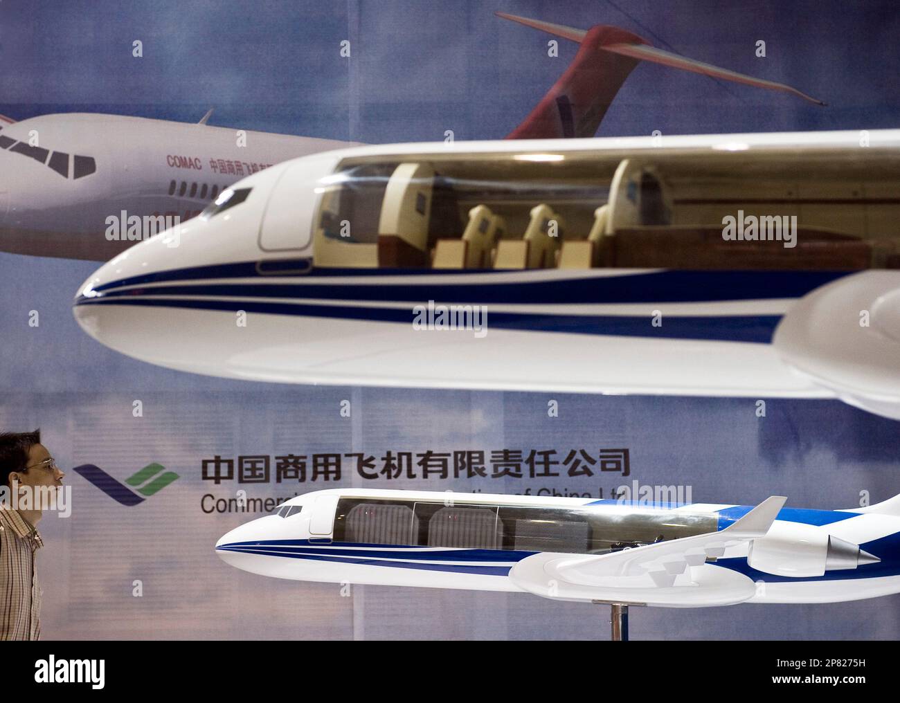 A man looks at Chinese made commercial airliner ARJ21 models on display ...