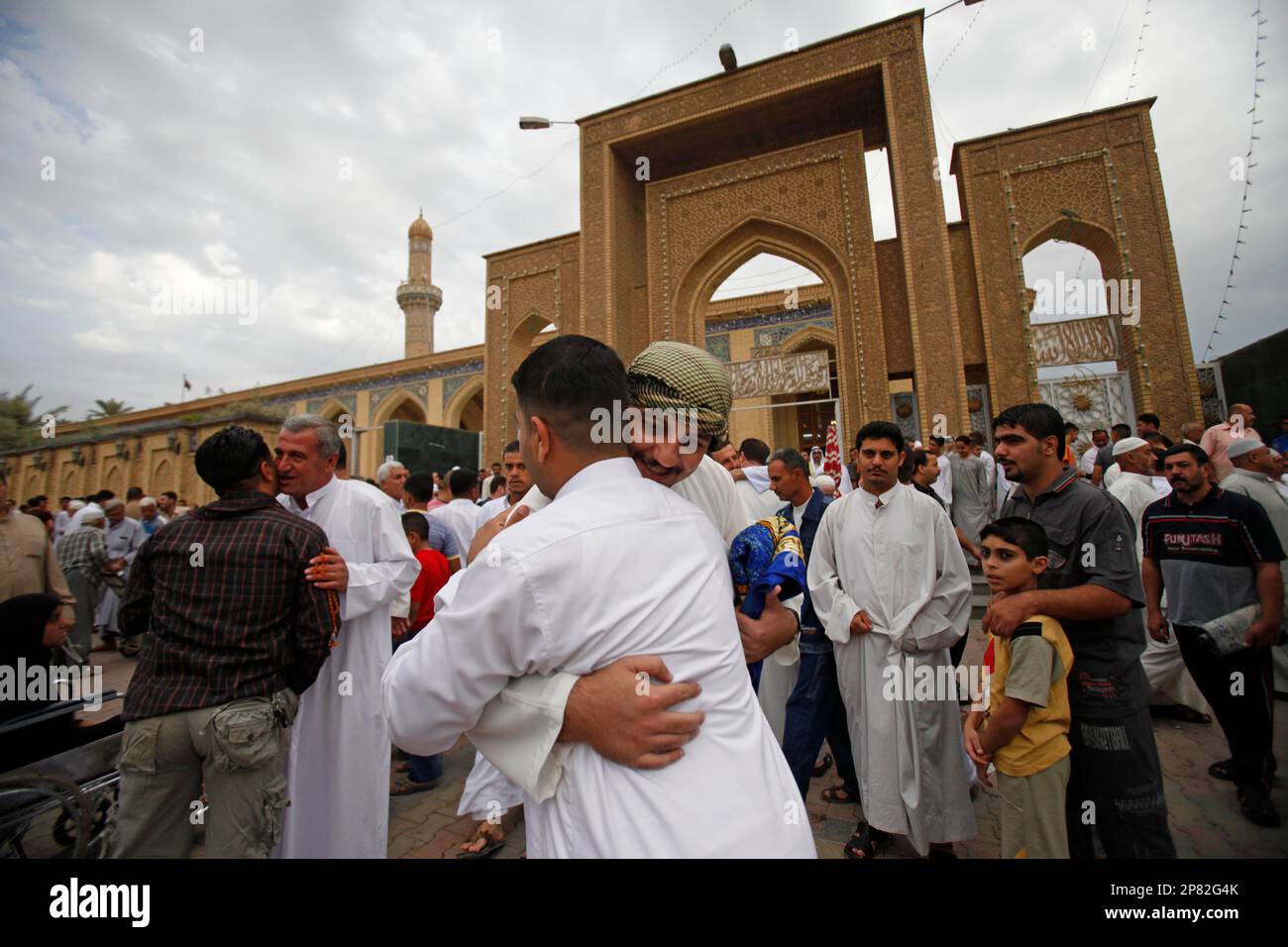 Iraqi Sunni Muslims exchange greetings after Eid prayers outside Abu ...
