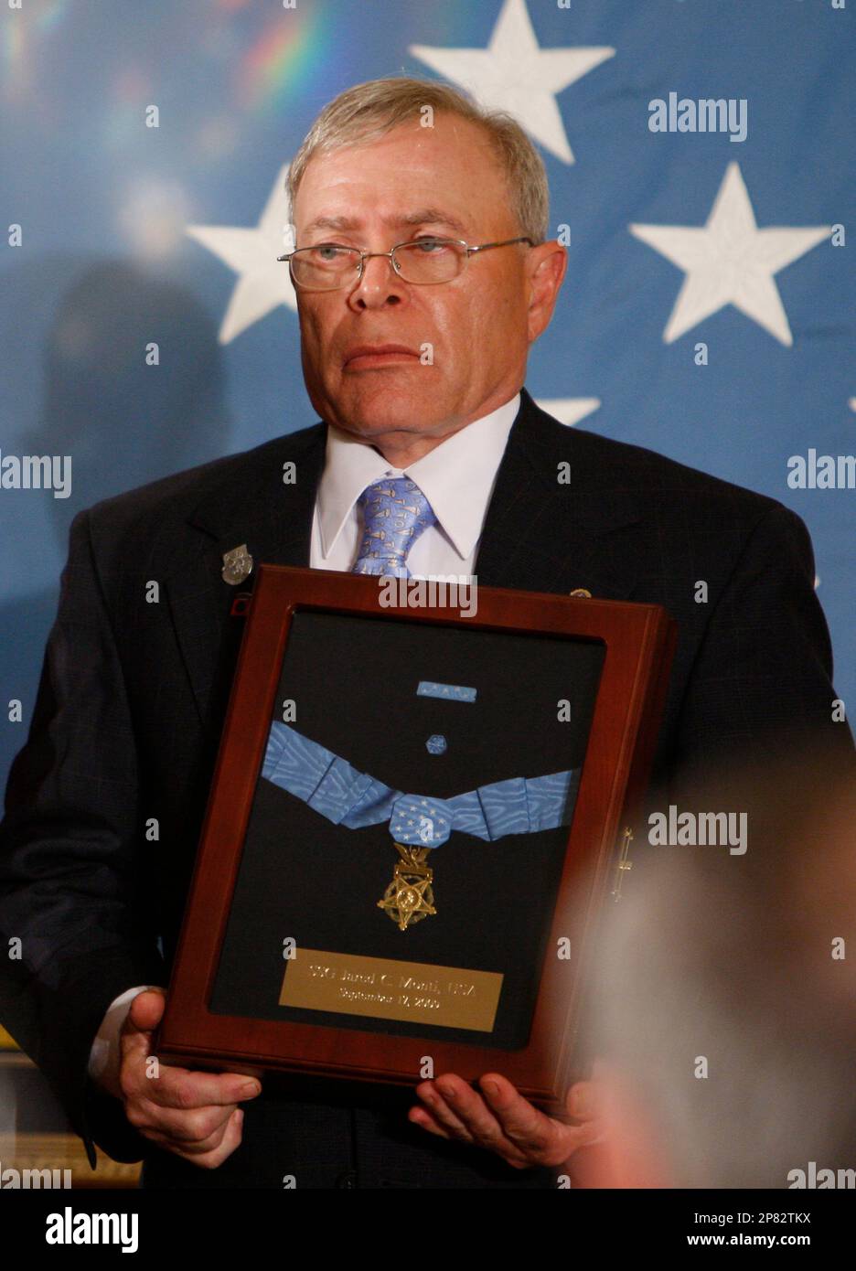 Paul Monti holds up his son's Medal of Honor after it was presented to ...