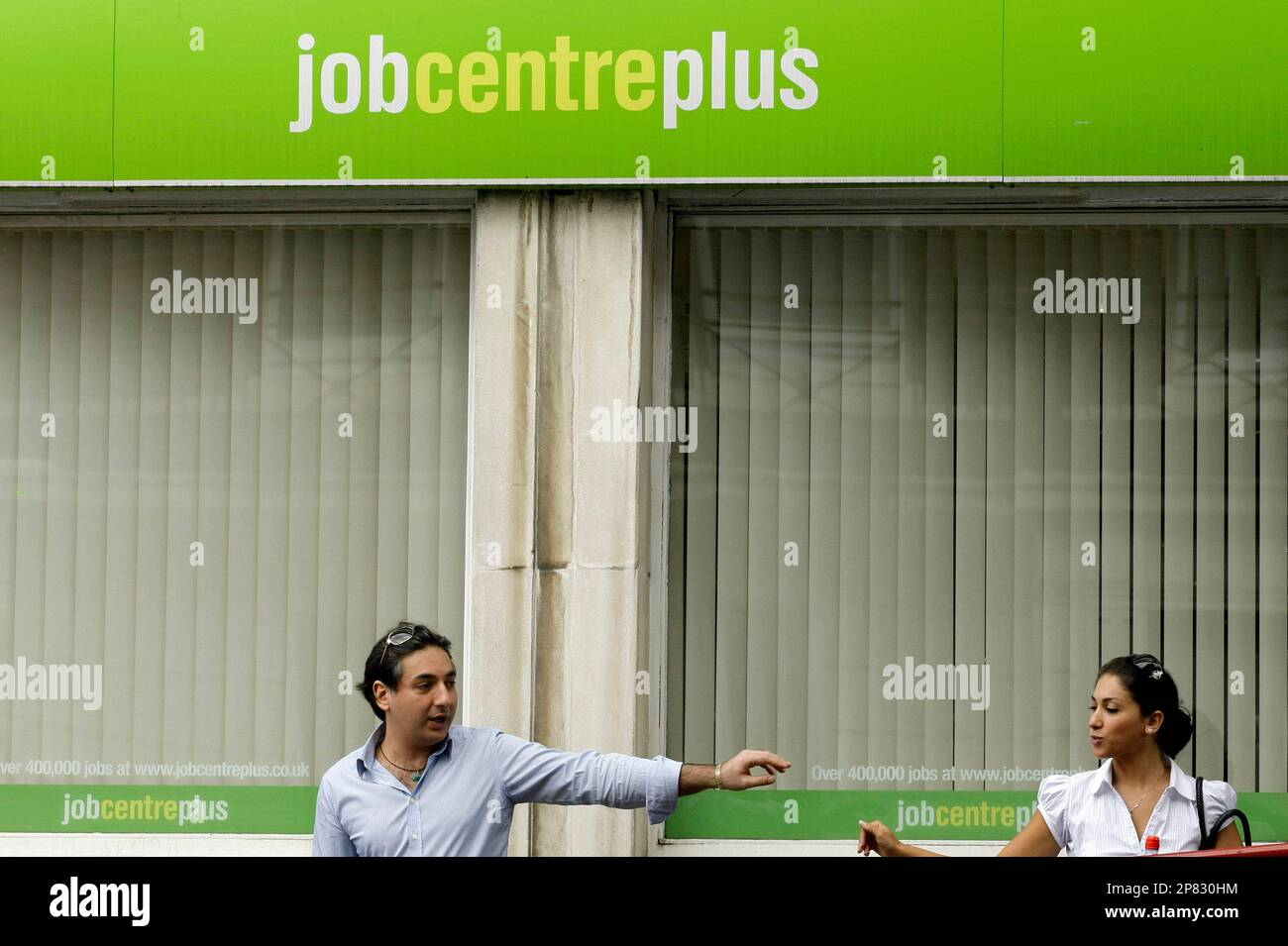 People are seen outside a job center in London, England, Wednesday ...