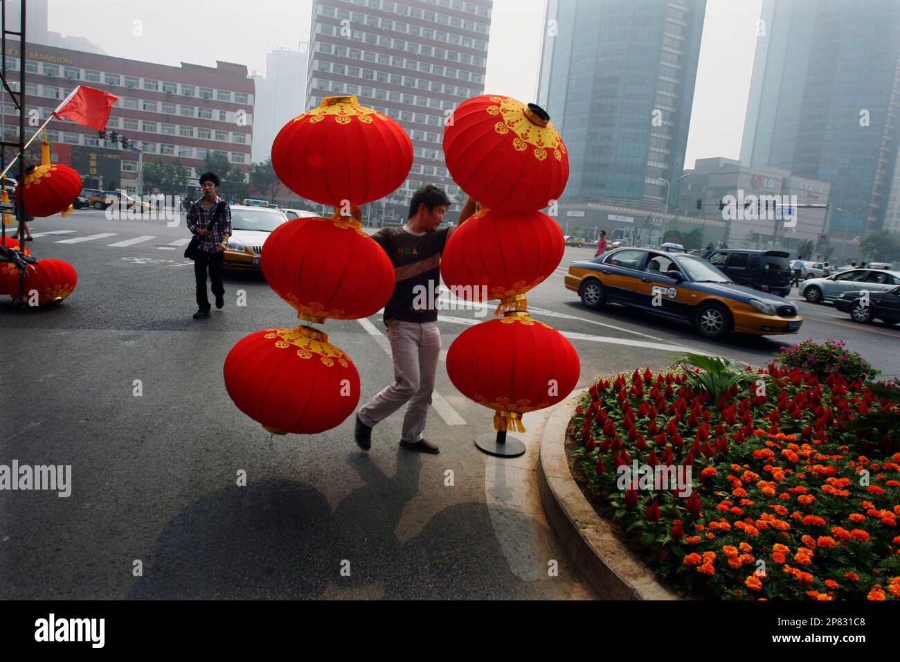 A Chinese worker prepares to set up Chinese lanterns to decorate a main ...